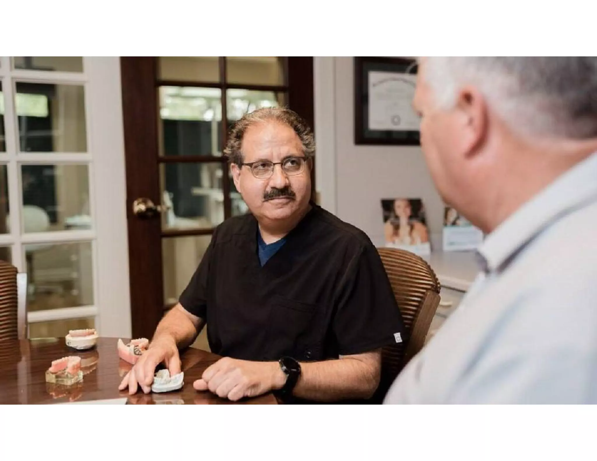 Sioux Falls dentist Dr. Kusek explaining dental implant options at ...